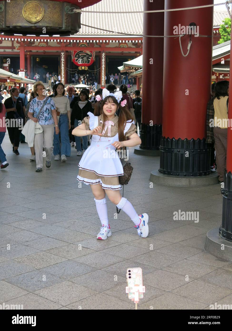 A Japanese young woman in 'cute style' pinafore dress poses to take ...