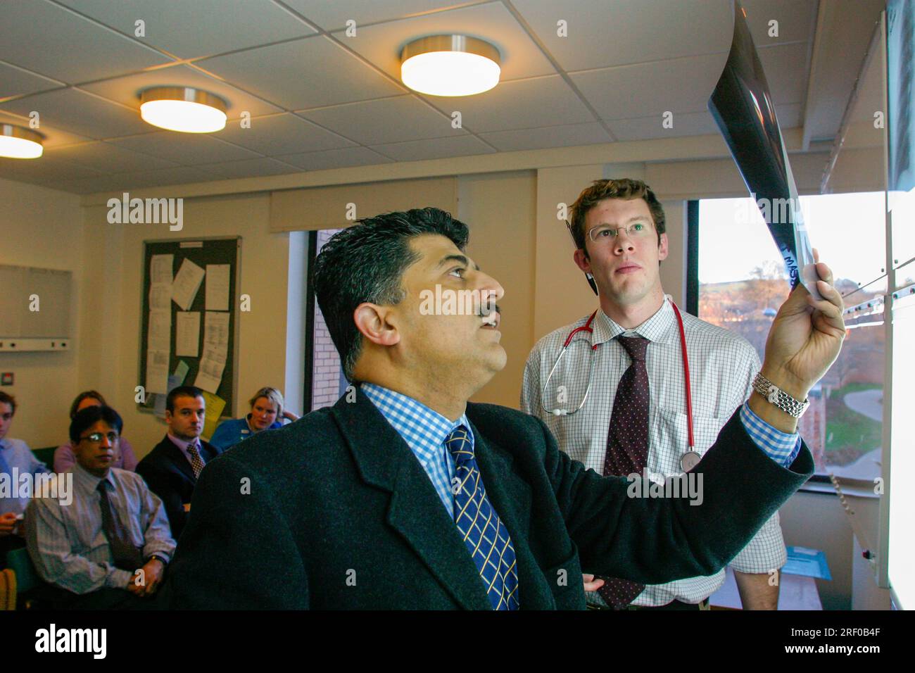 Doctors review a patient's X-ray in a medical training room with ...
