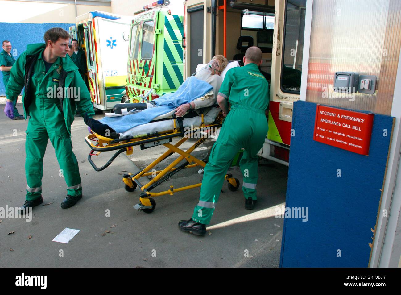 Paramedics move a patient on a stretcher into an ambulance outside an ...