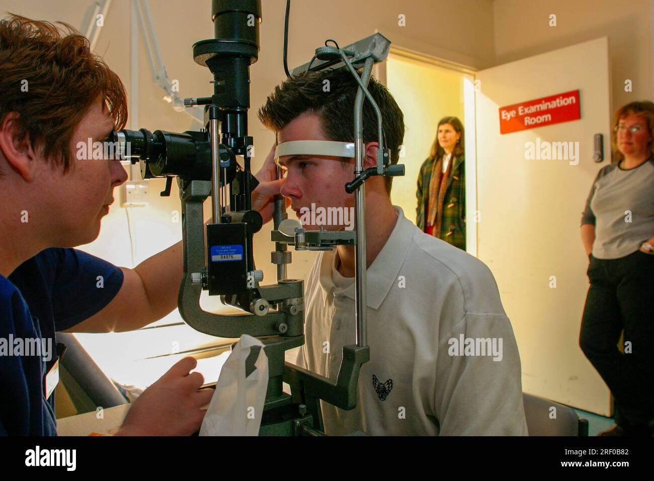 An eye examination in progress at a clinic, with medical staff and ...