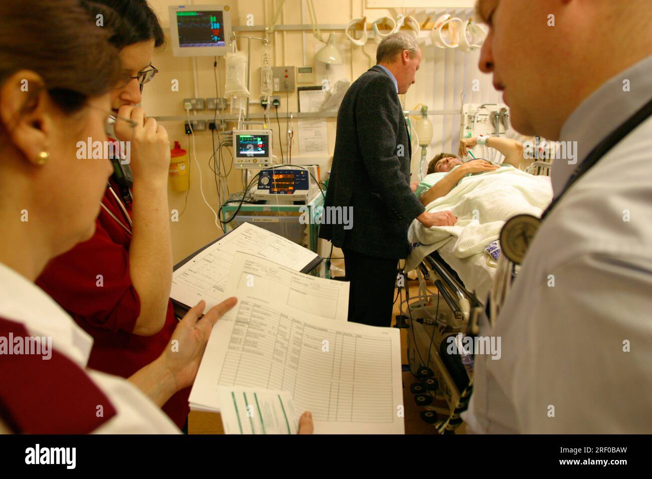 Medical team consults near a patient in a hospital's emergency room ...