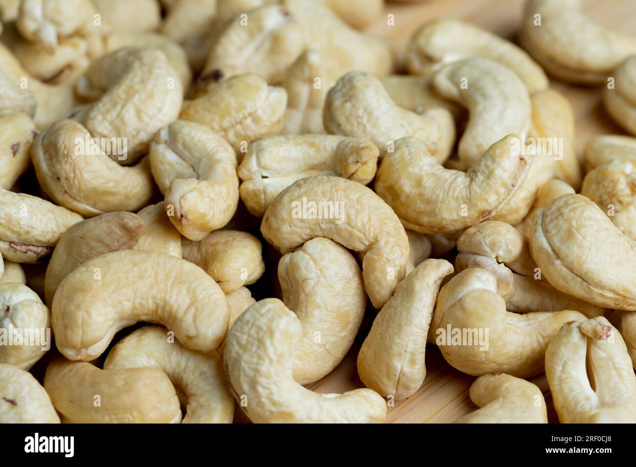 Delicious cashew nuts on a wooden surface, ready to eat and peeled ...