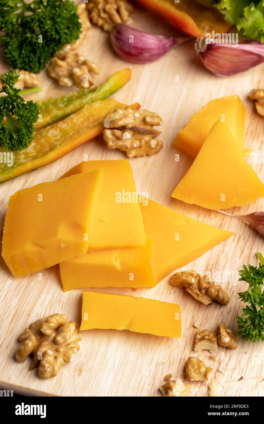 Sliced hard cheese made from milk, real aged yellow cheese on a board ...