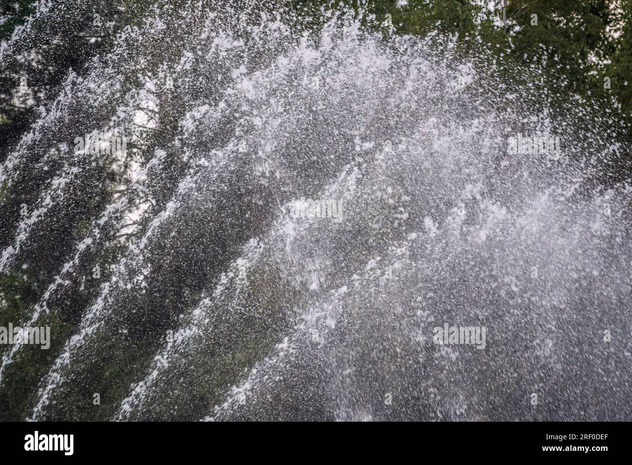 Water splashes from fountain on dark background. Natural texture of ...