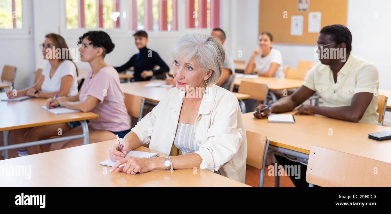 Focused motivated older woman listening to lecture in classroom Stock ...