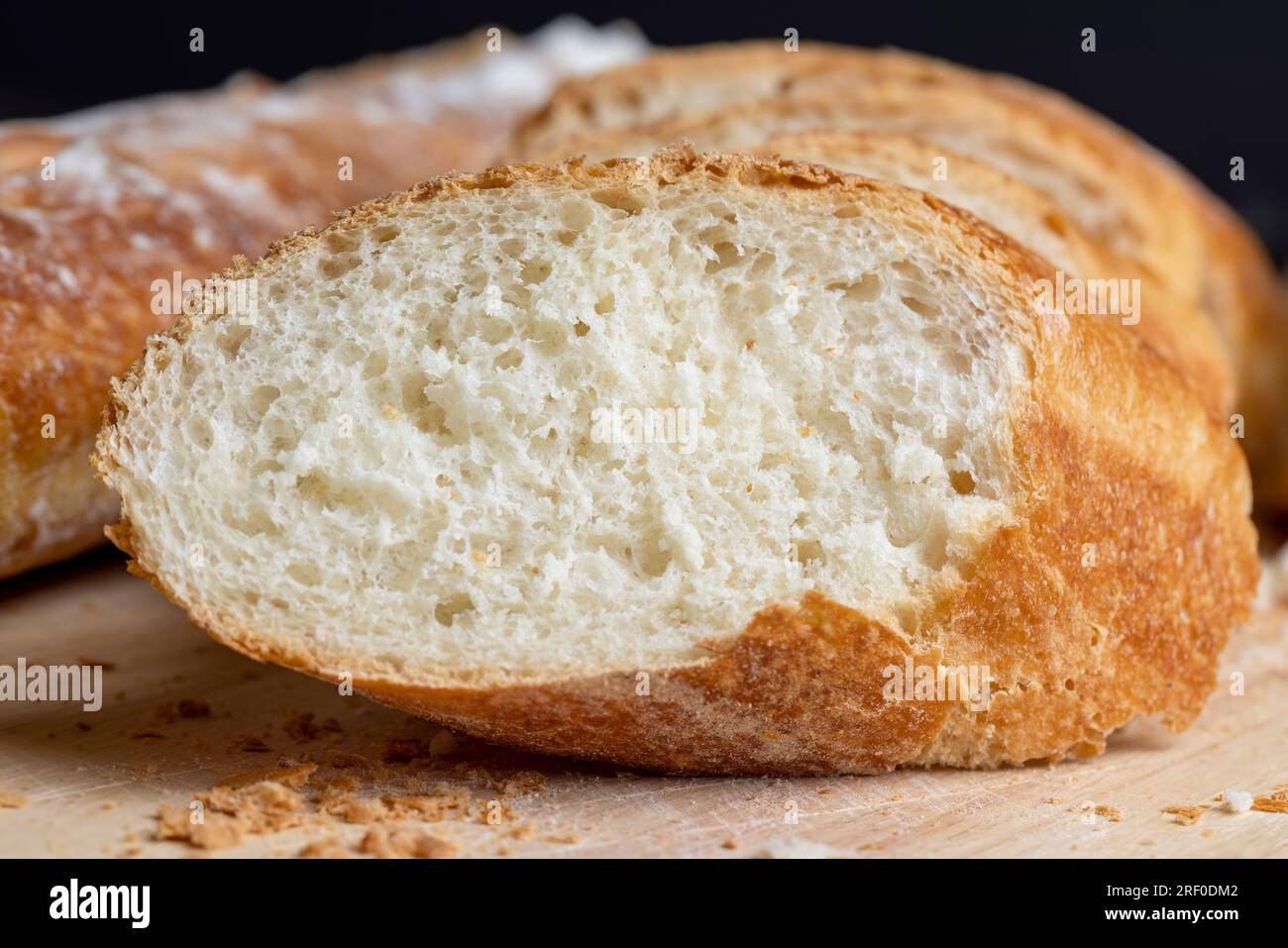 Cut white bread into pieces, traditional white baguette with porous ...