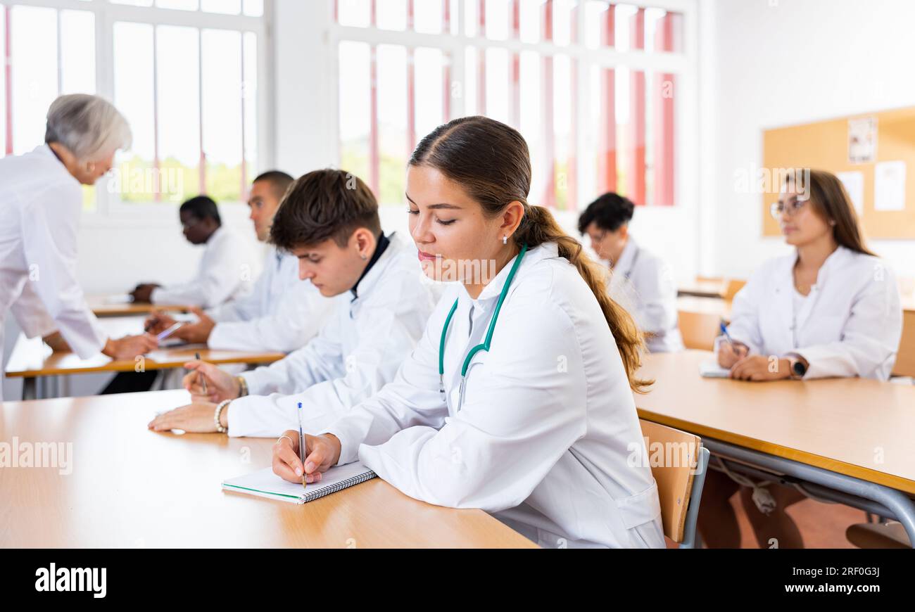 Young female student listening to lecture during professional medical ...