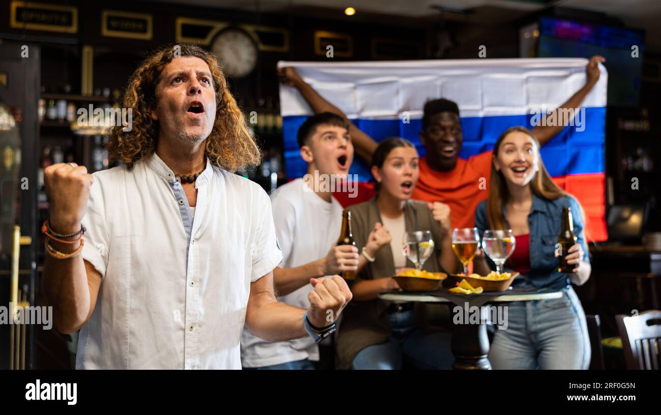 Cheerful international soccer football fans waving Russian flag and ...
