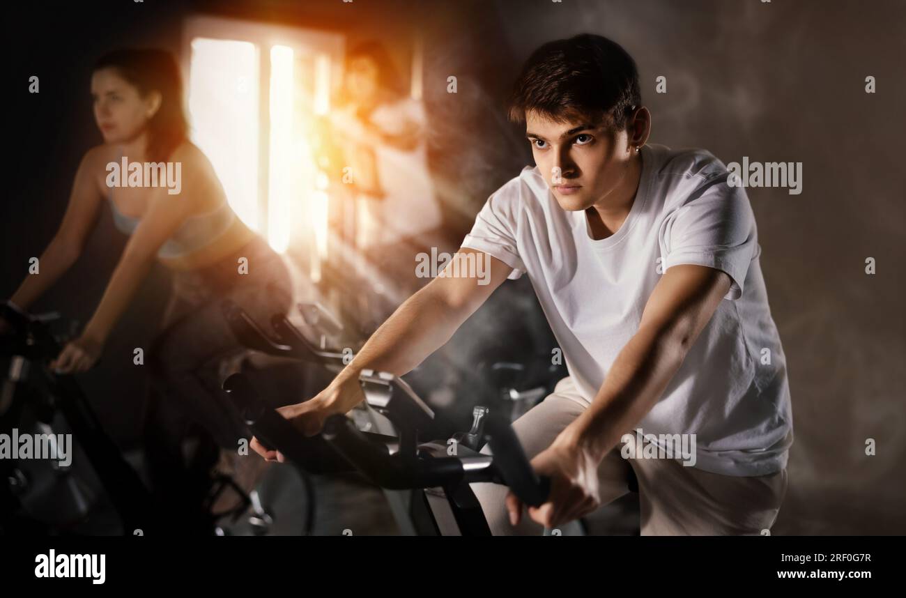 Guy doing cardio training on stationary bike in gym Stock Photo - Alamy