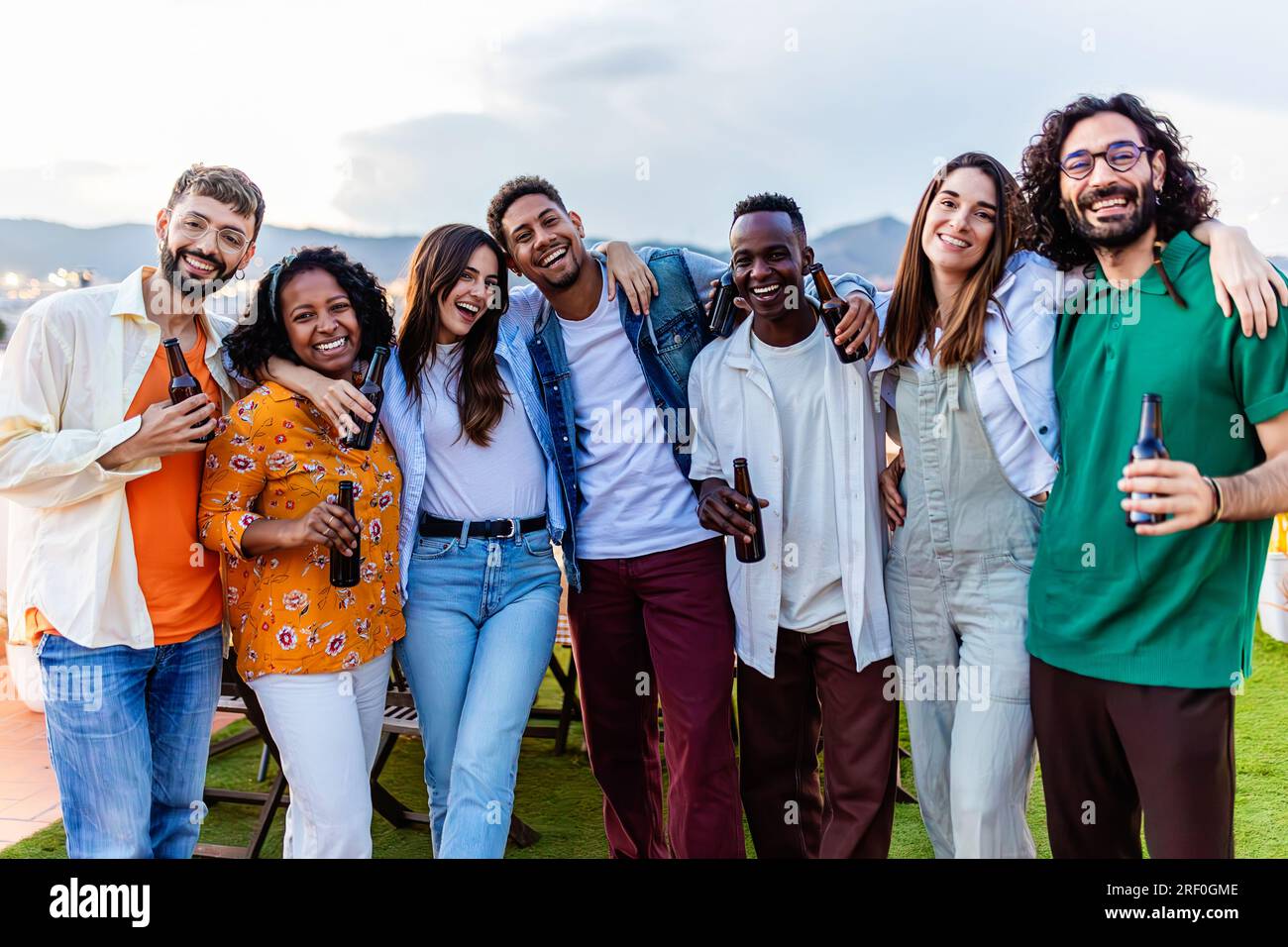 Group portrait of young diverse friends standing together at rooftop ...