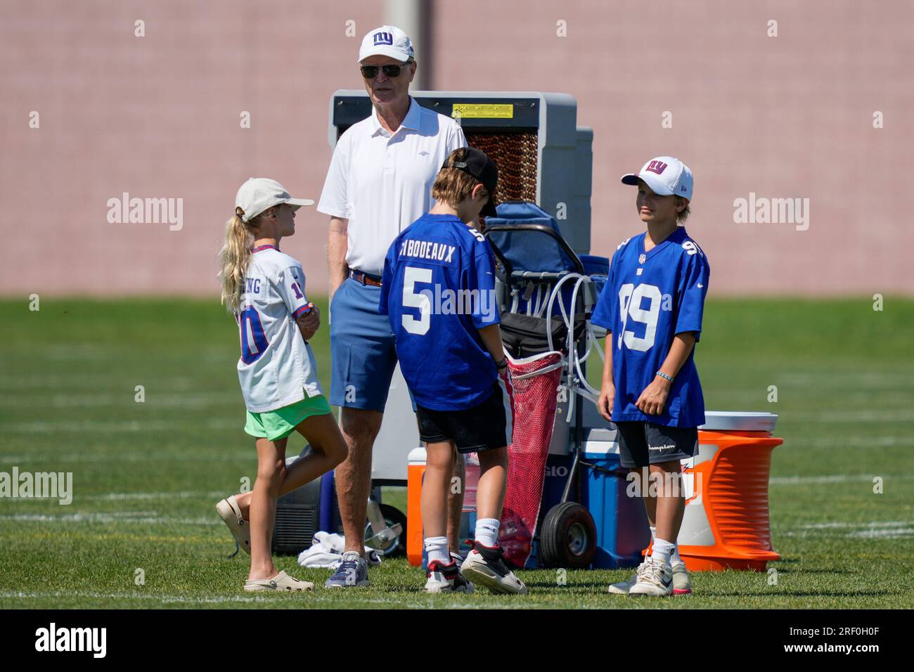 New York Giants owner John Mara stands with children on the sidelines ...