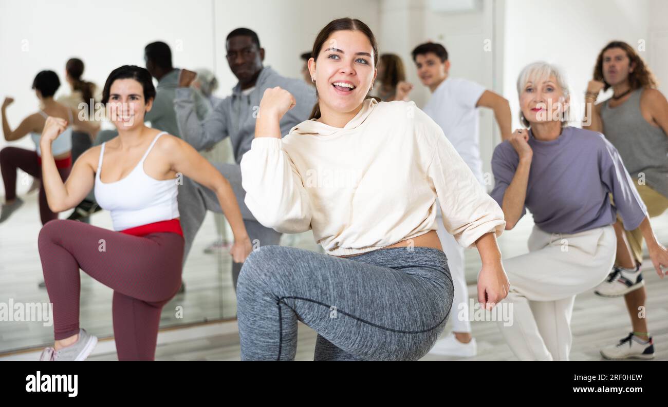 Cheerful girl enjoying active dancing during group training Stock Photo ...