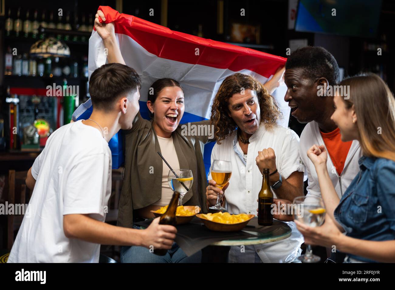 Happy international soccer supporters holding up the flag of ...
