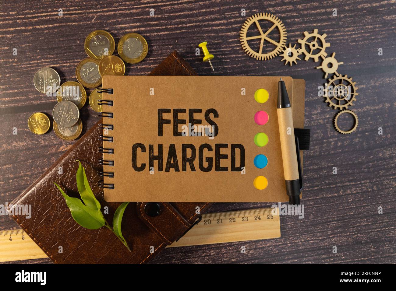 FEES CHARGED text on notebook with clipboard and calculator on chart ...