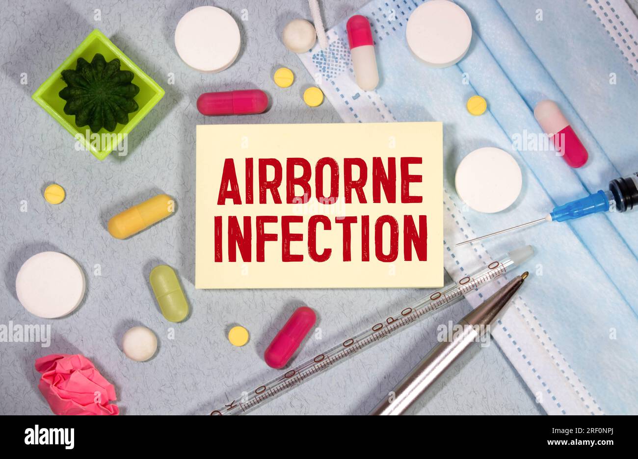 The text AIRBORNE INFECTION is written in a yellow notebook that lies ...