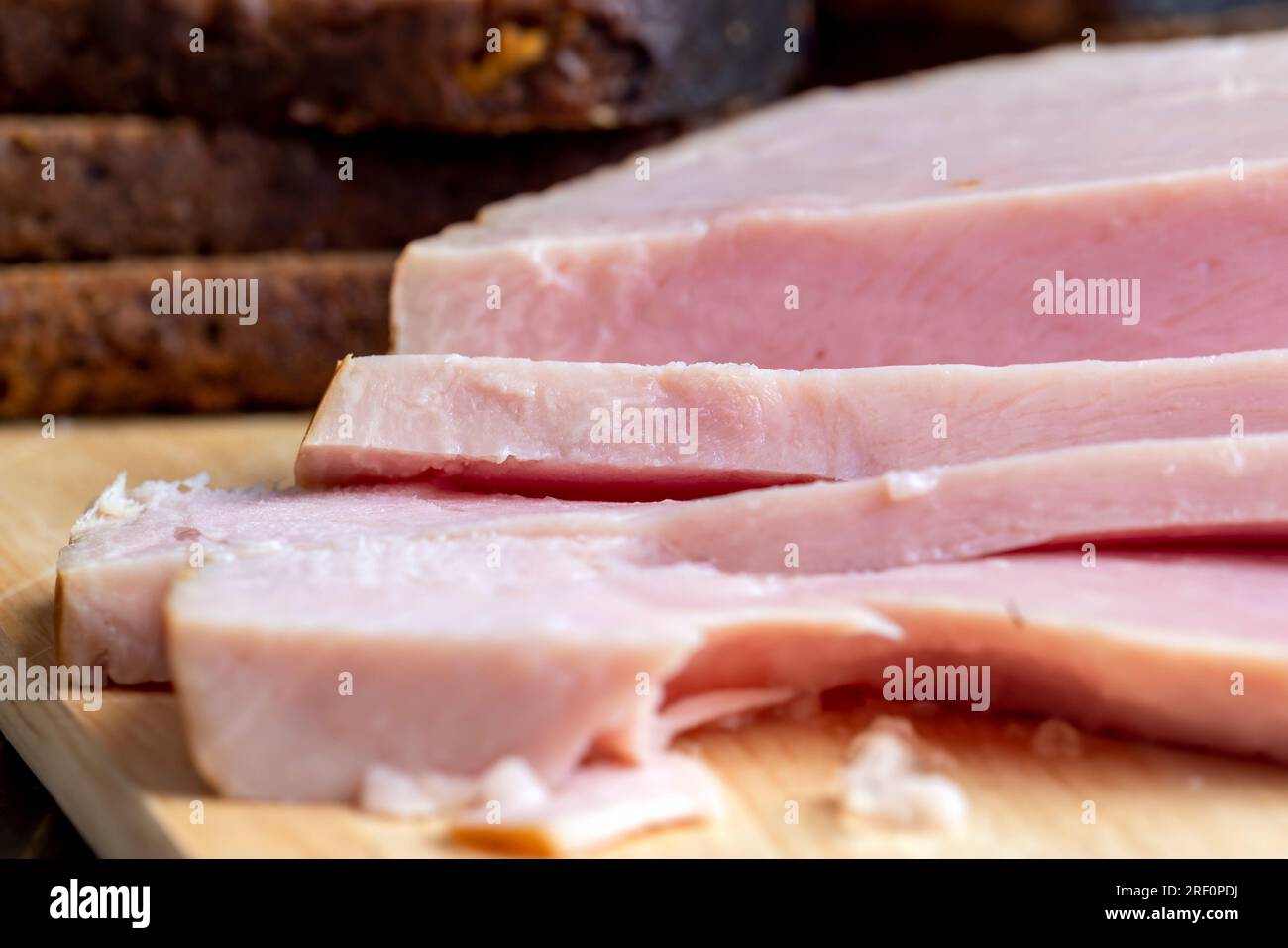 A sliced piece of delicious pork meat , ready-made meat food on a board ...