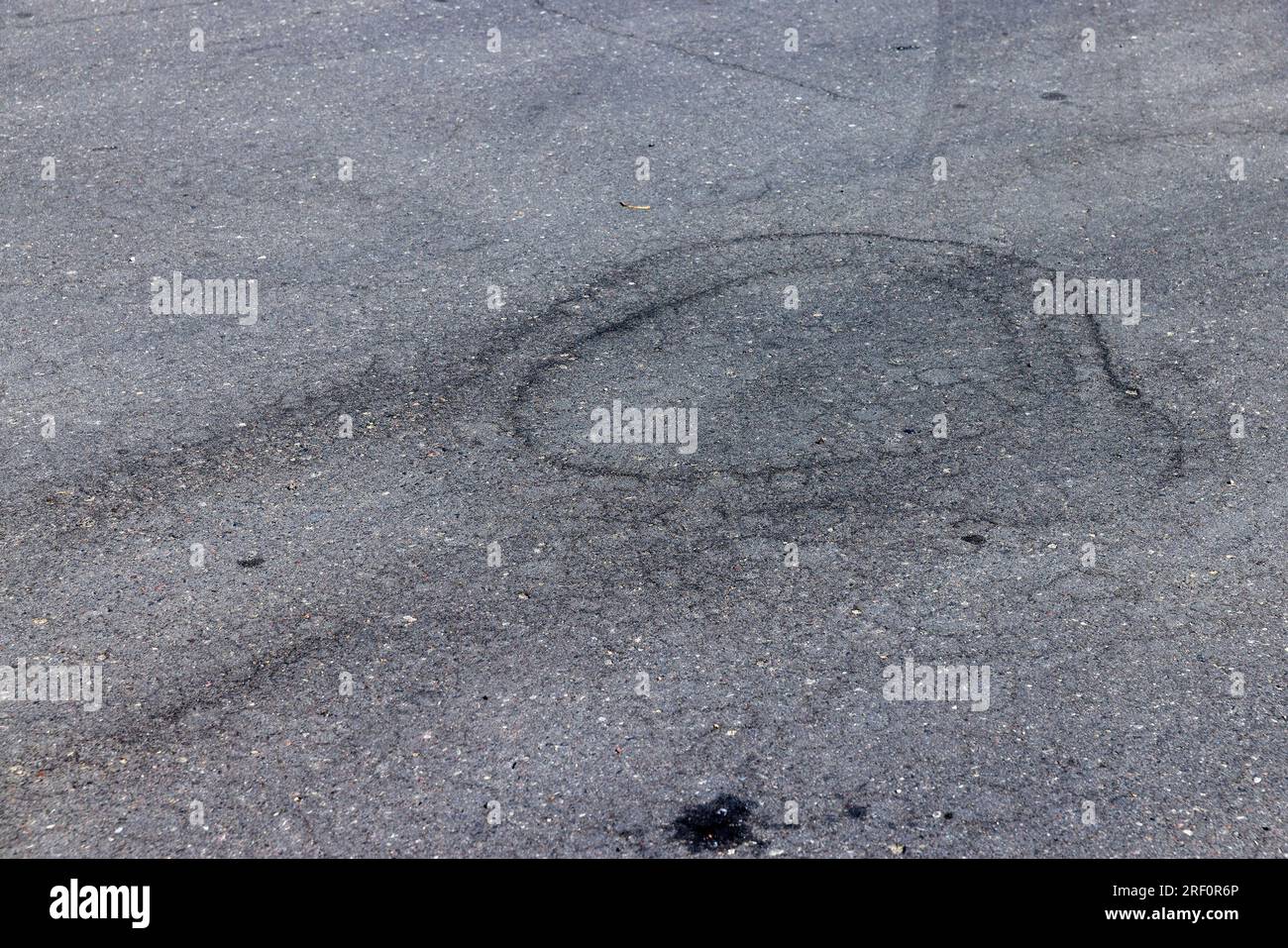 Paved road with engine oil stains and other pollution from cars, part ...