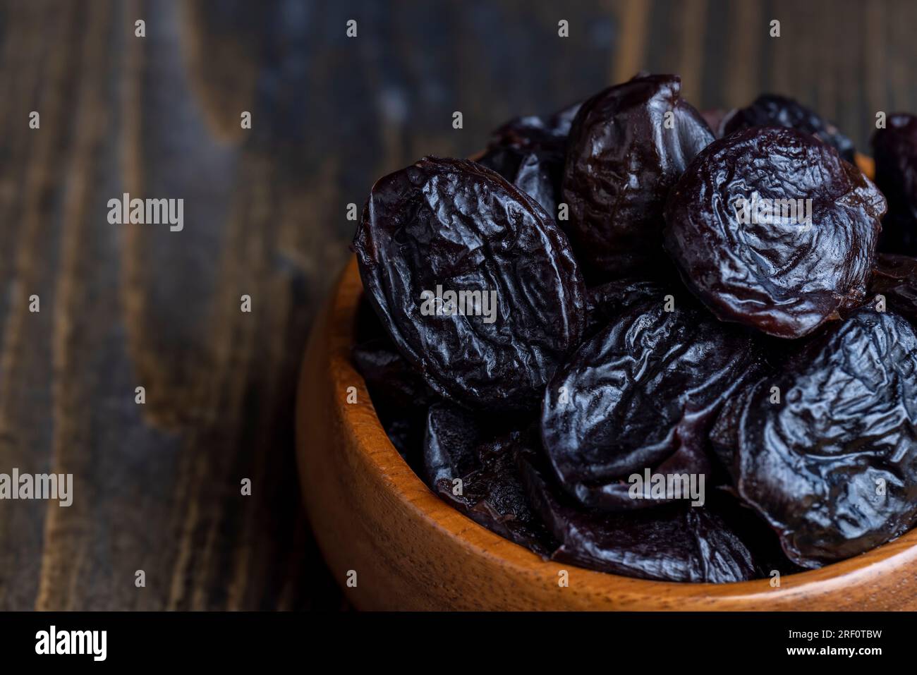 Dried plums on the kitchen table, dried sweet pitted prunes Stock Photo ...