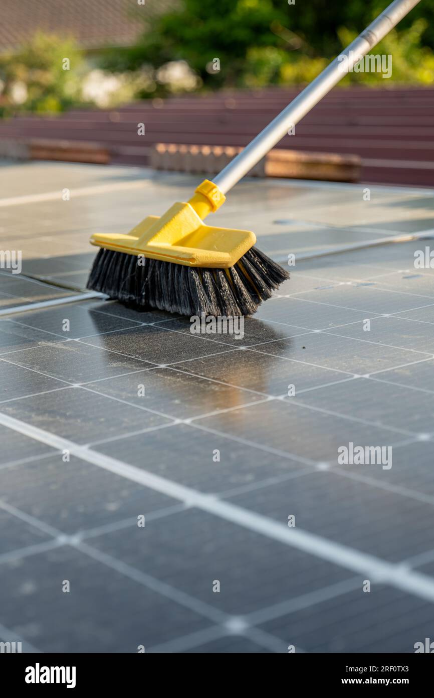 washing solar panels from dust on the roof with water close-up.Solar ...