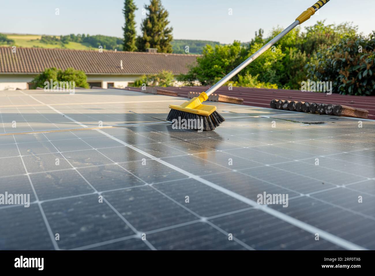 washing solar panels from dust and dirt on the roof with water close-up ...