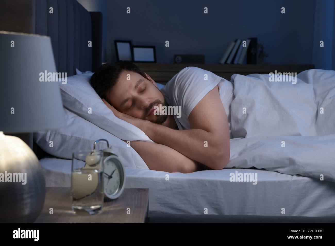 Handsome man sleeping in bed at night Stock Photo - Alamy