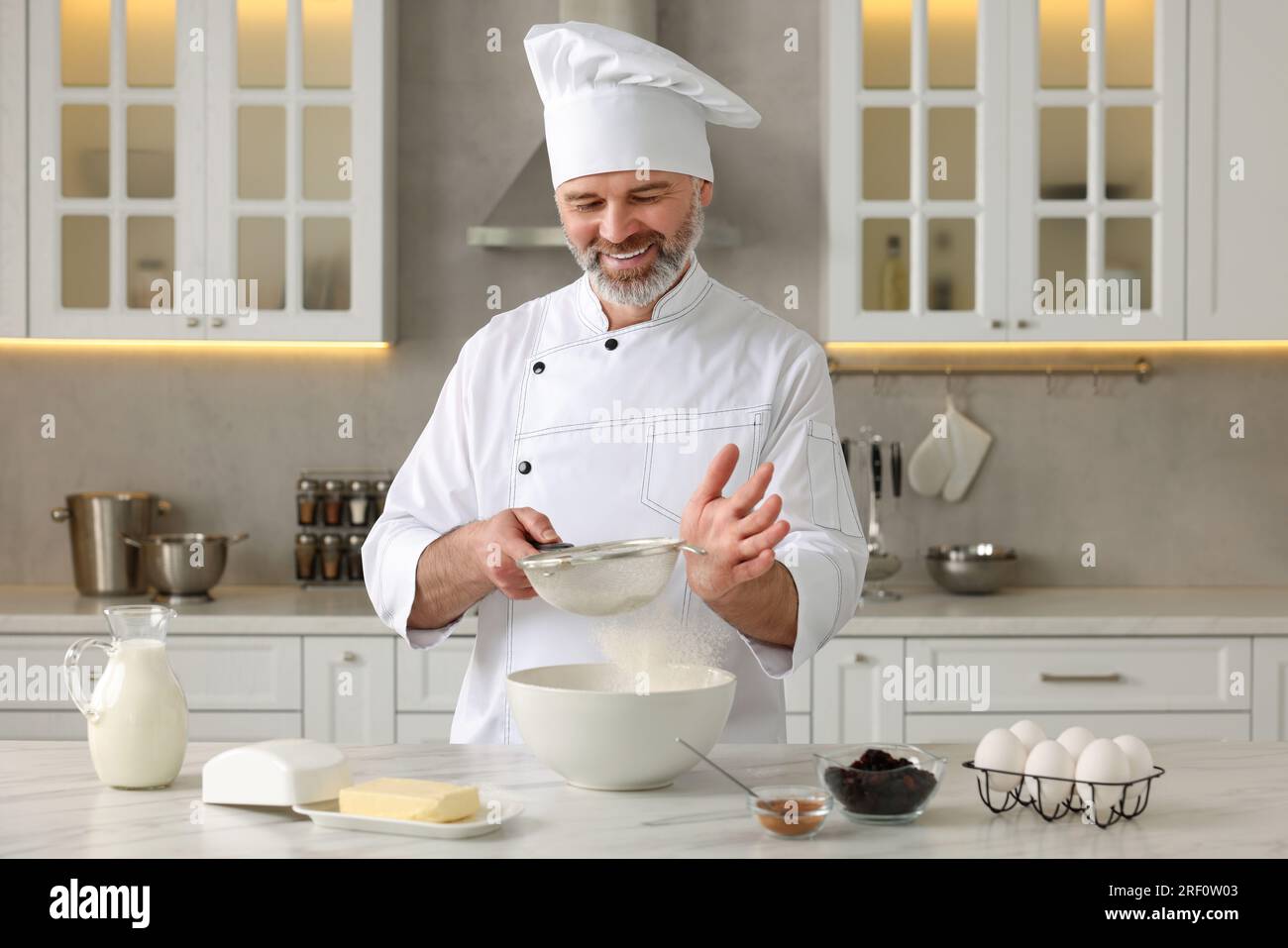 Professional chef making dough at white marble table in kitchen Stock ...