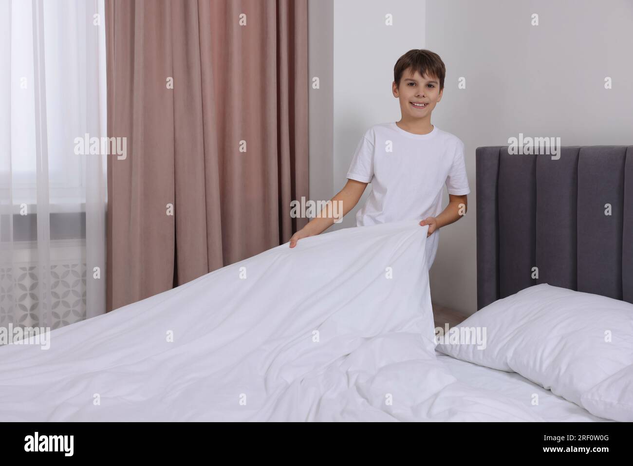 Boy changing bed linens in bedroom. Domestic chores Stock Photo - Alamy