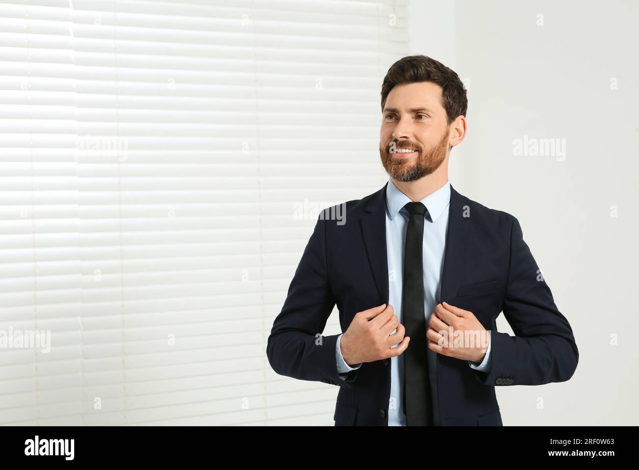 Handsome real estate agent in nice suit indoors, space for text Stock ...