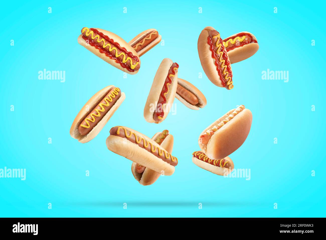 Many tasty hot dogs falling on light blue background Stock Photo - Alamy