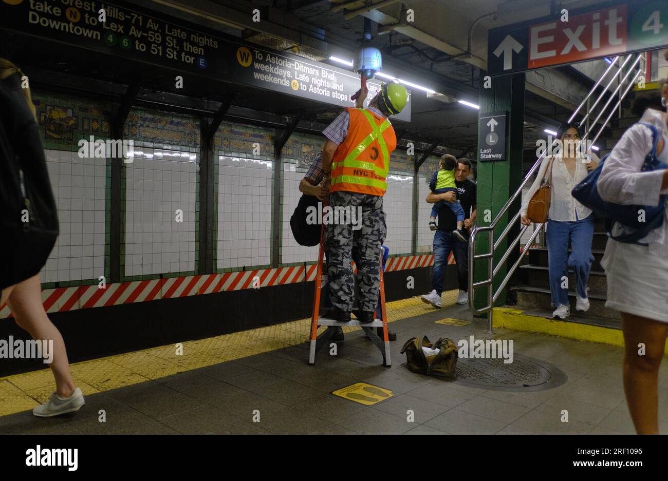 New York, New York, USA. 30th July, 2023. MTA worker installs a ...