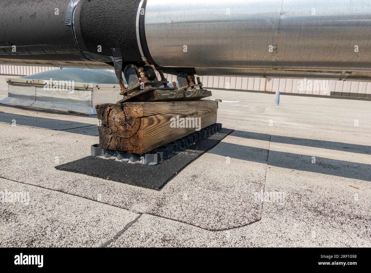 Roof mounted industrial insulated HVAC pipes on gray roof and wooden ...