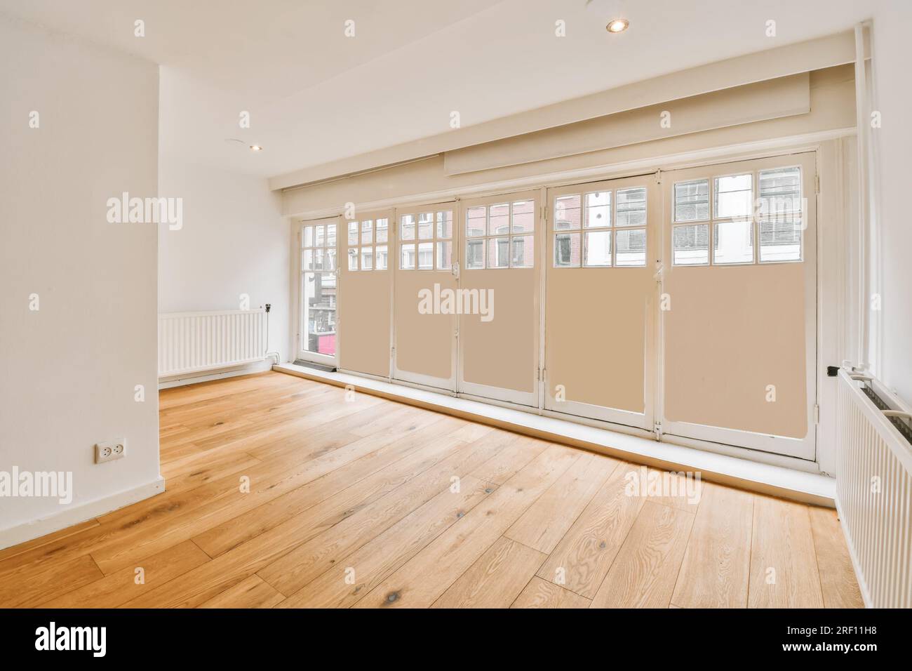 an empty living room with wood flooring and sliding doors on either ...