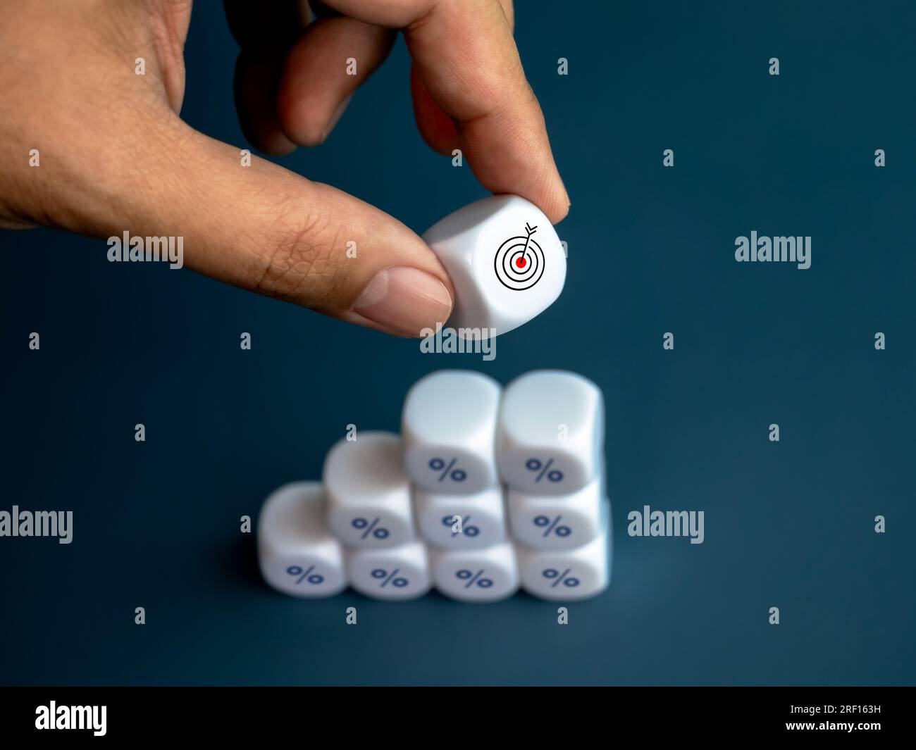 Goal target icon on white blocks holding by hand on business chart ...