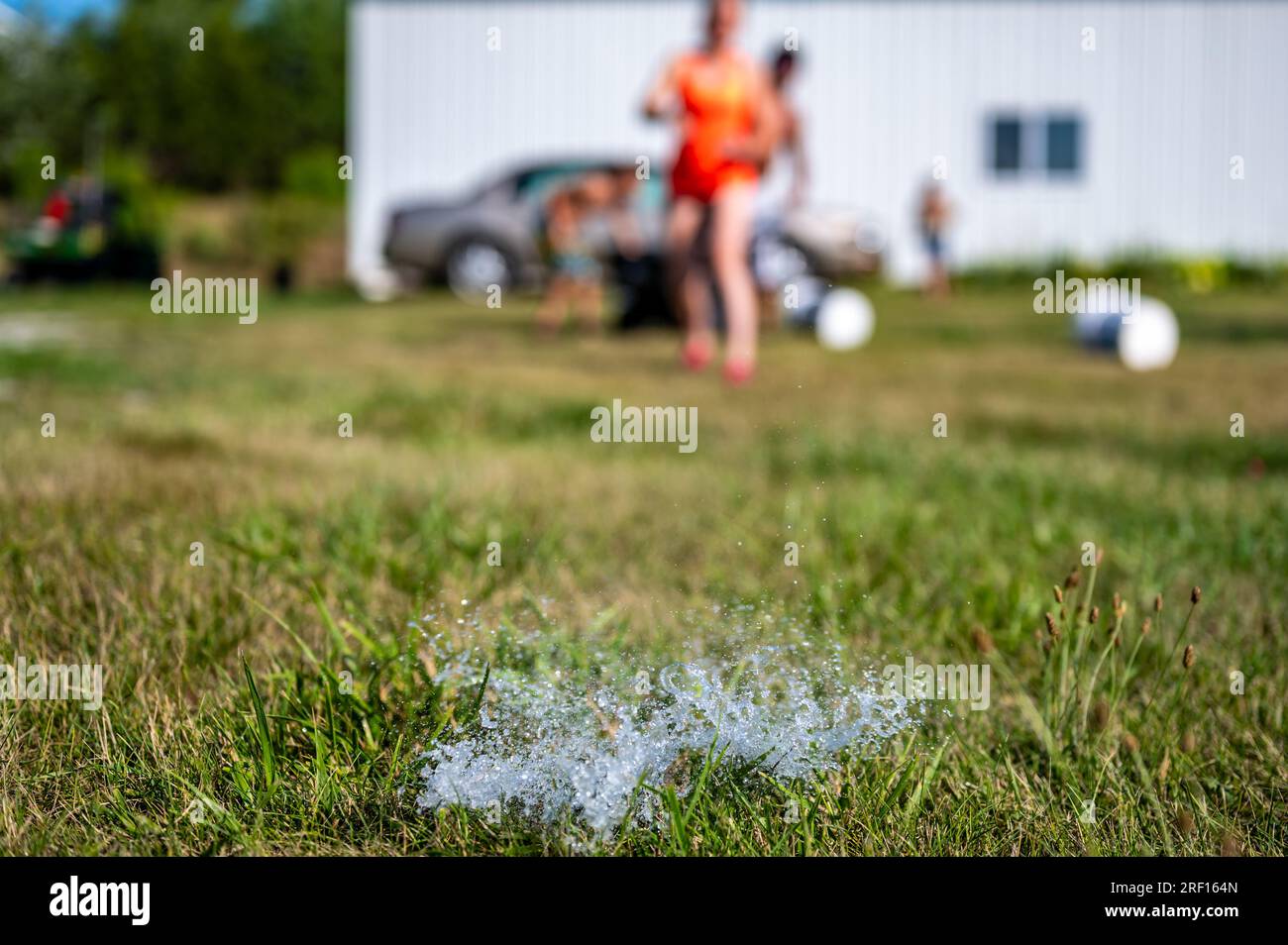 Water droplets bursting from a water balloon directly after impact ...