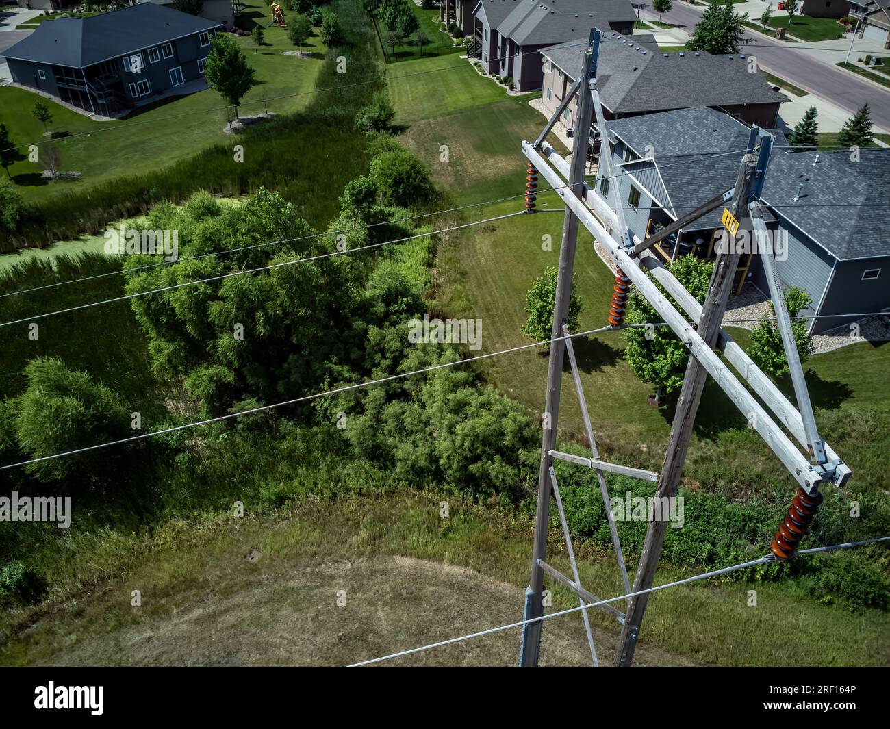 Drone aerial view of high voltage power lines through a residential ...