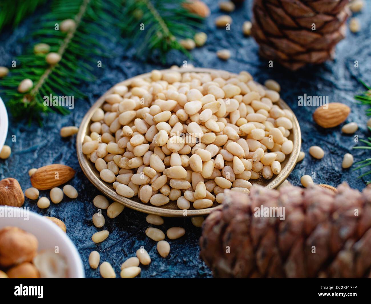 Peeled pine nuts lie in plate among cones. Still life of pine nut ...