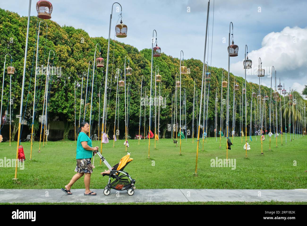 A woman pushes a pram through the area of Kebun Baru Birdsinging Club ...