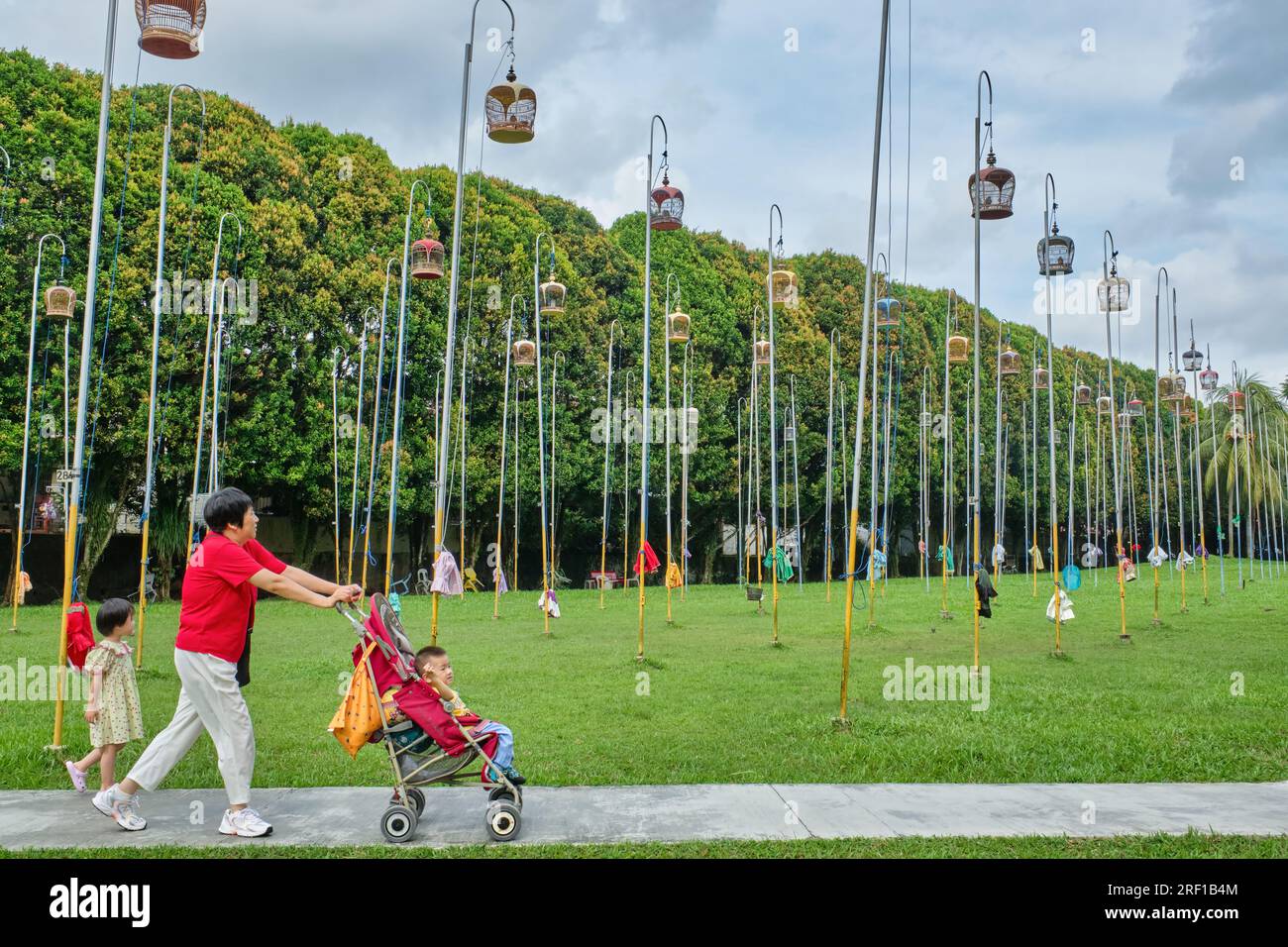 A woman pushes a pram through the area of Kebun Baru Birdsinging Club ...