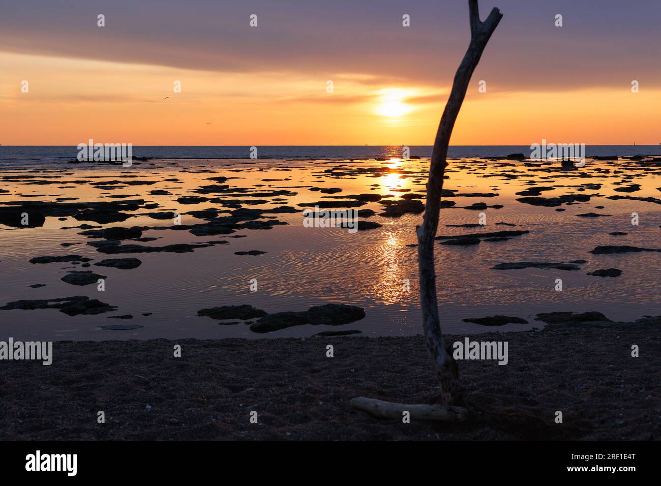 Sunset Reflected on the Sea as in a Mirror with Rocks Emerging on the ...