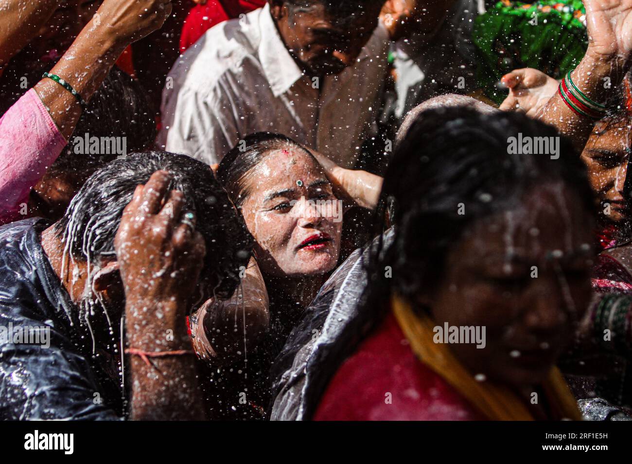 A Hindu women takes a Holy bath in milk offers prayer to the Idol of ...