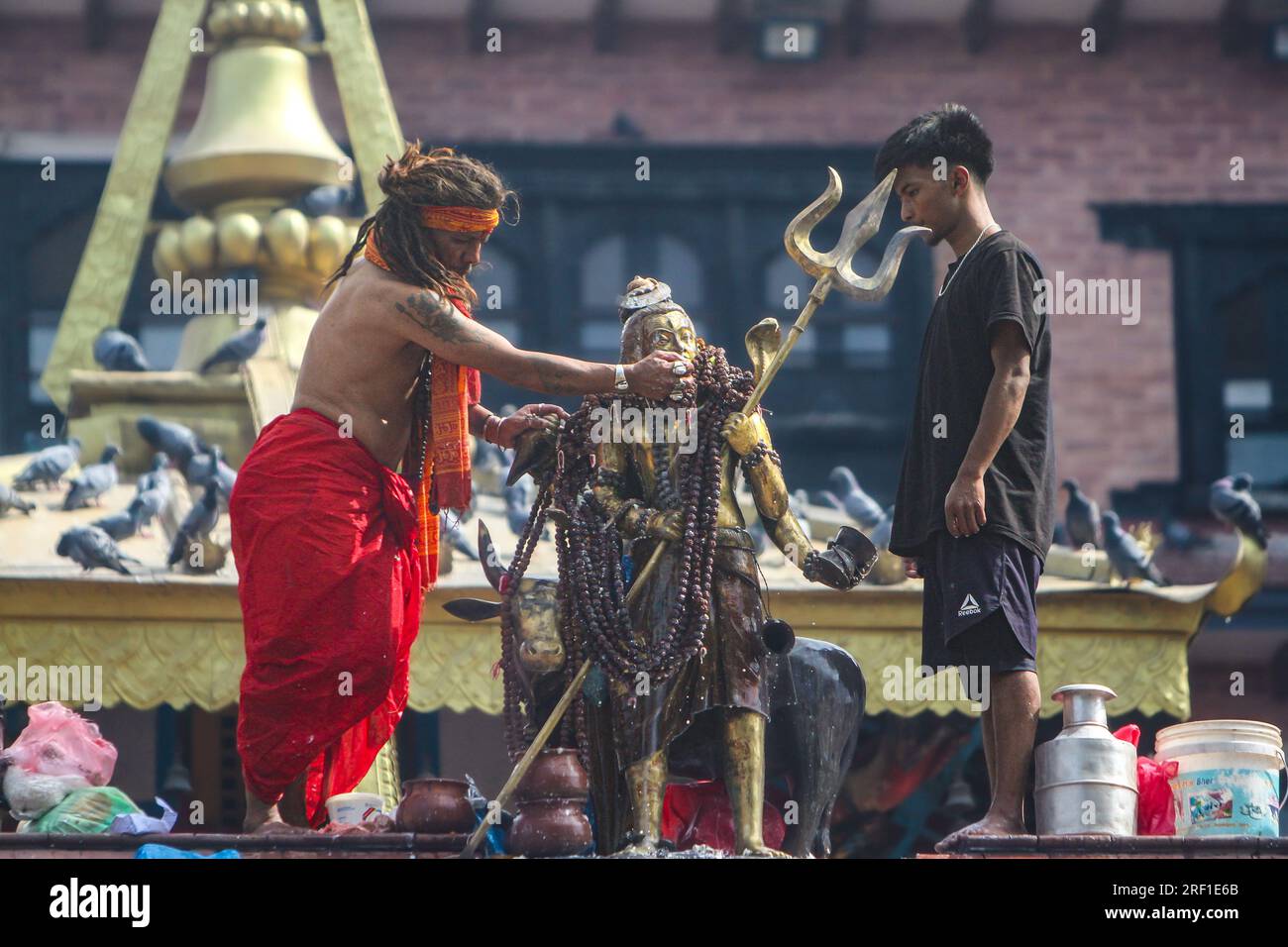 A Hindu priest offers ritual prayer to the Idol of Lord Shiva at Shiva ...