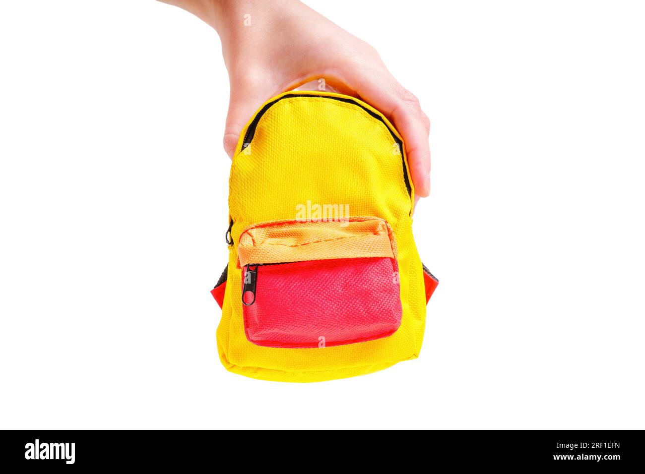 Hand holding a tiny yellow and red backpack isolated on white ...