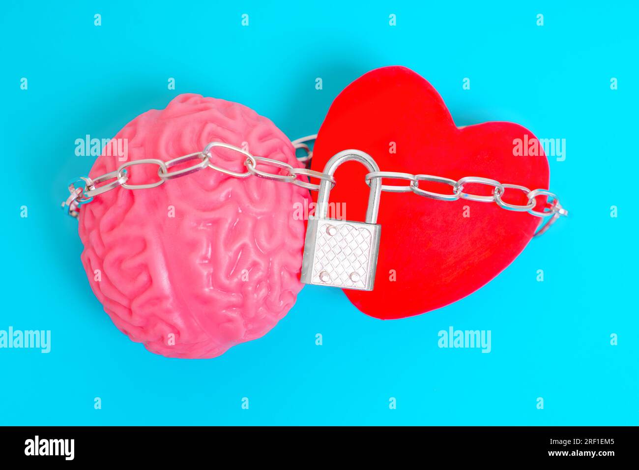 Heart and brain, bound tightly together by a chain and secured with a ...