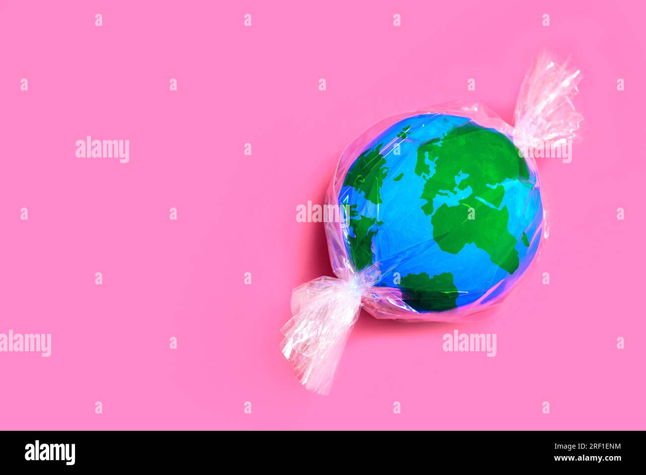 Miniature globe wrapped in plastic, resembling a candy. Global issue of ...