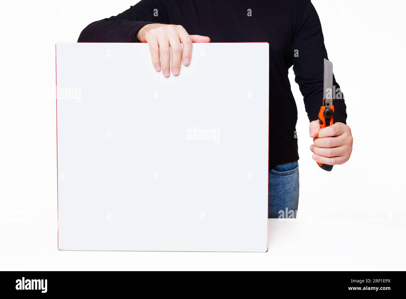 Person placing one hand on a large white box while holding a utility ...
