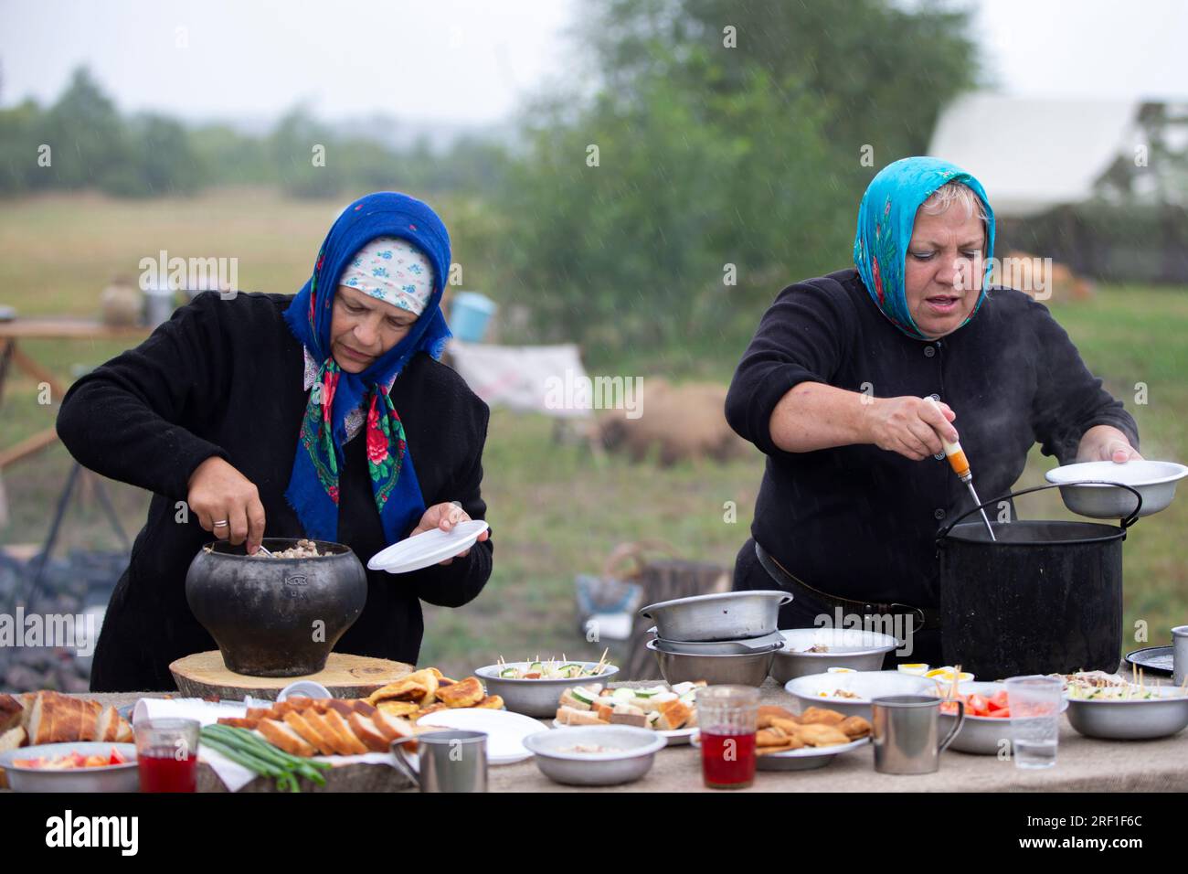 Refugee women prepare food outdoors in a refugee camp Stock Photo - Alamy