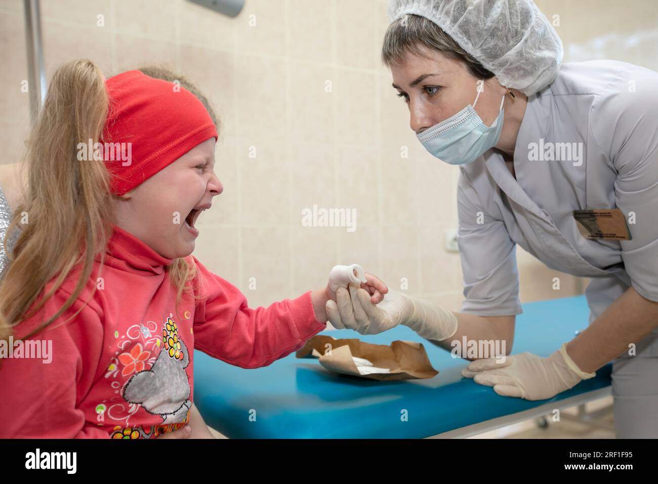 The hands of the doctor bandage the sore finger with a bandage of the ...