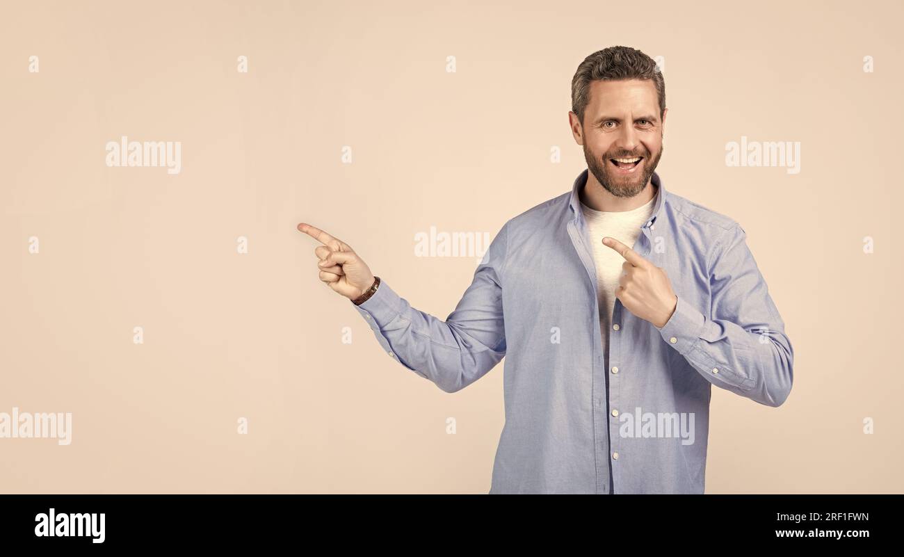 cheerful man pointing and offer advertisement in studio. photo of man ...