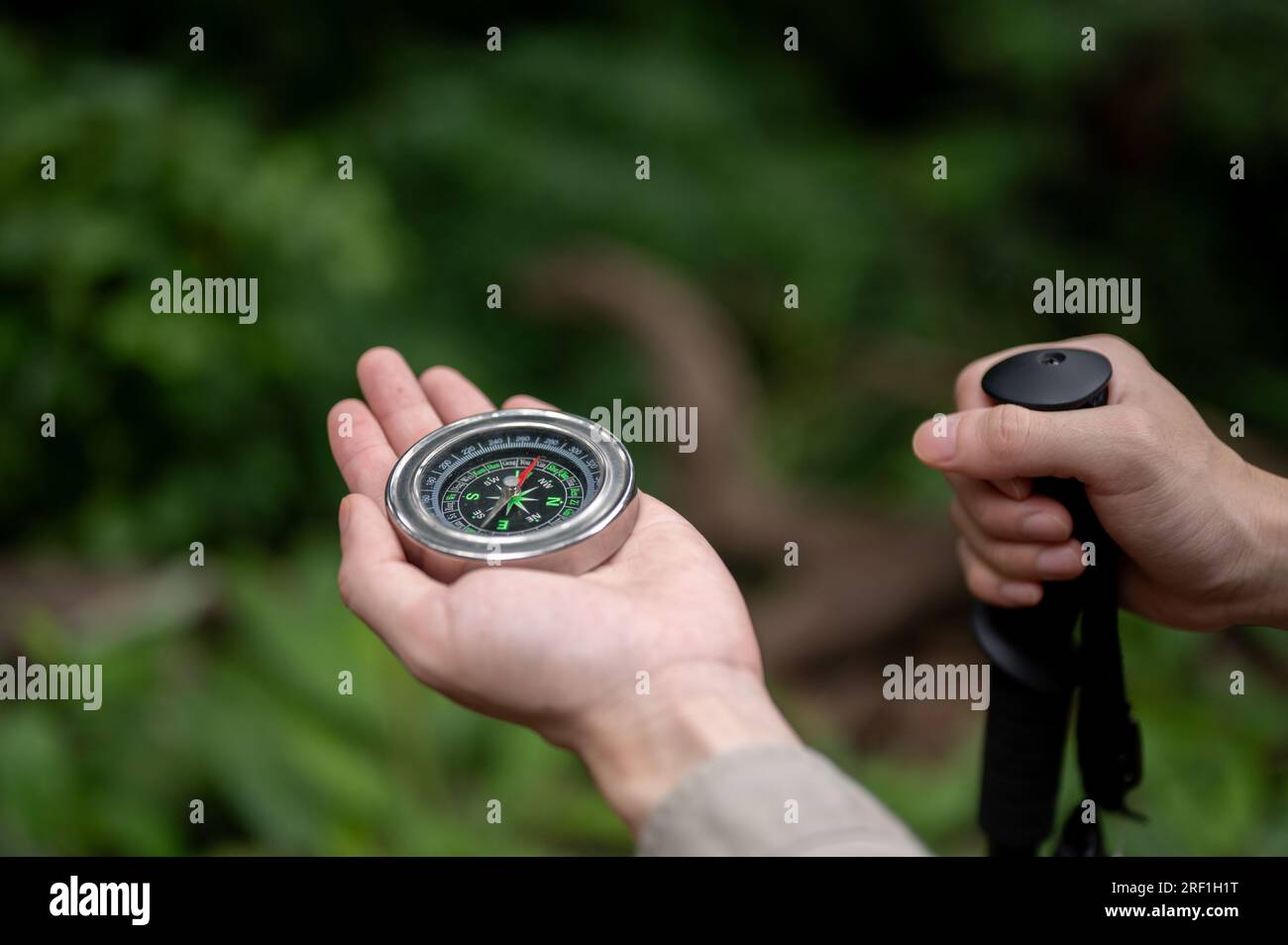 Close-up image of a male hiker holding a compass while hiking in the ...