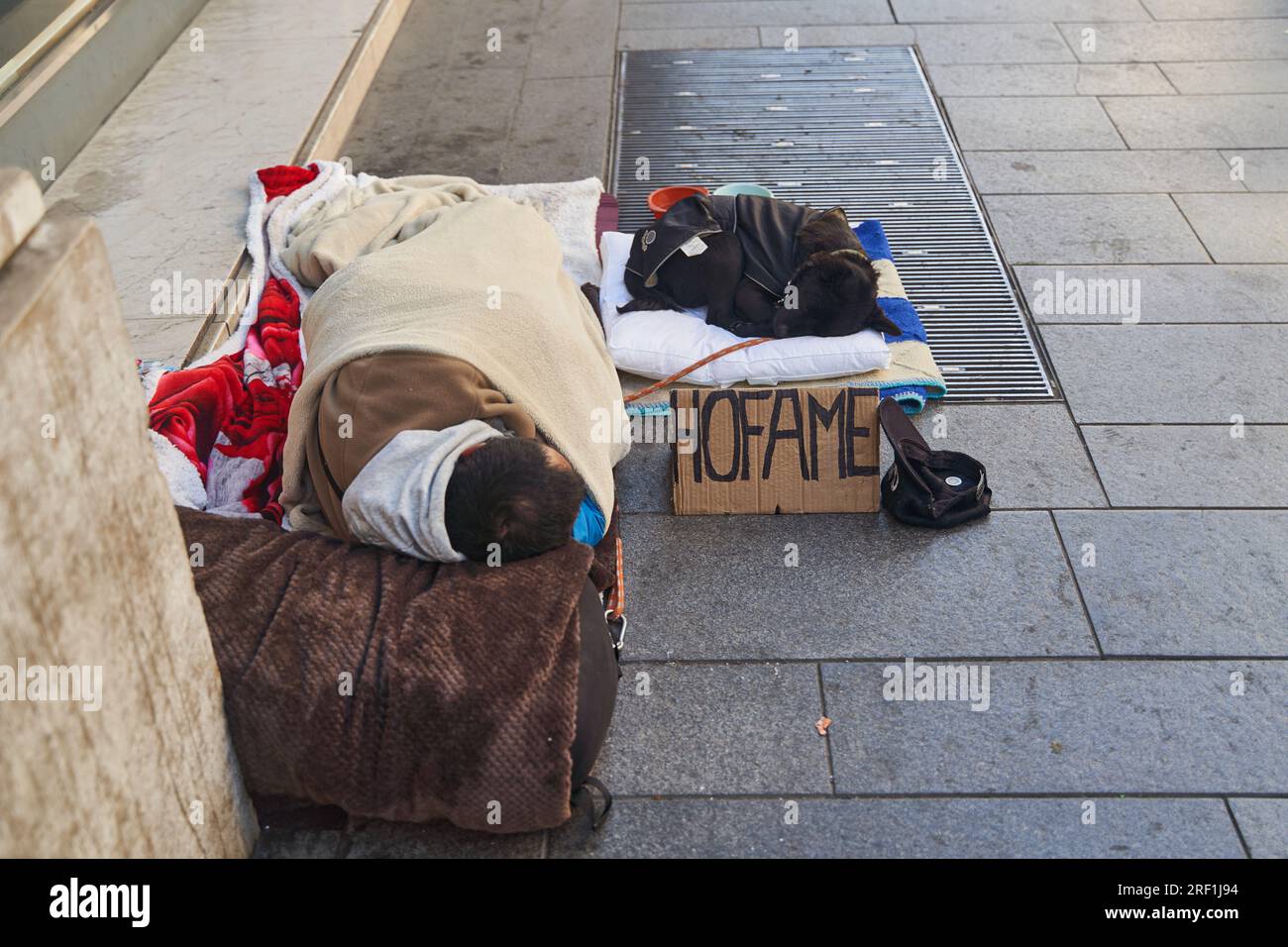 Milan, Italy February 2023: Poor homeless boy sleeping in the street in ...